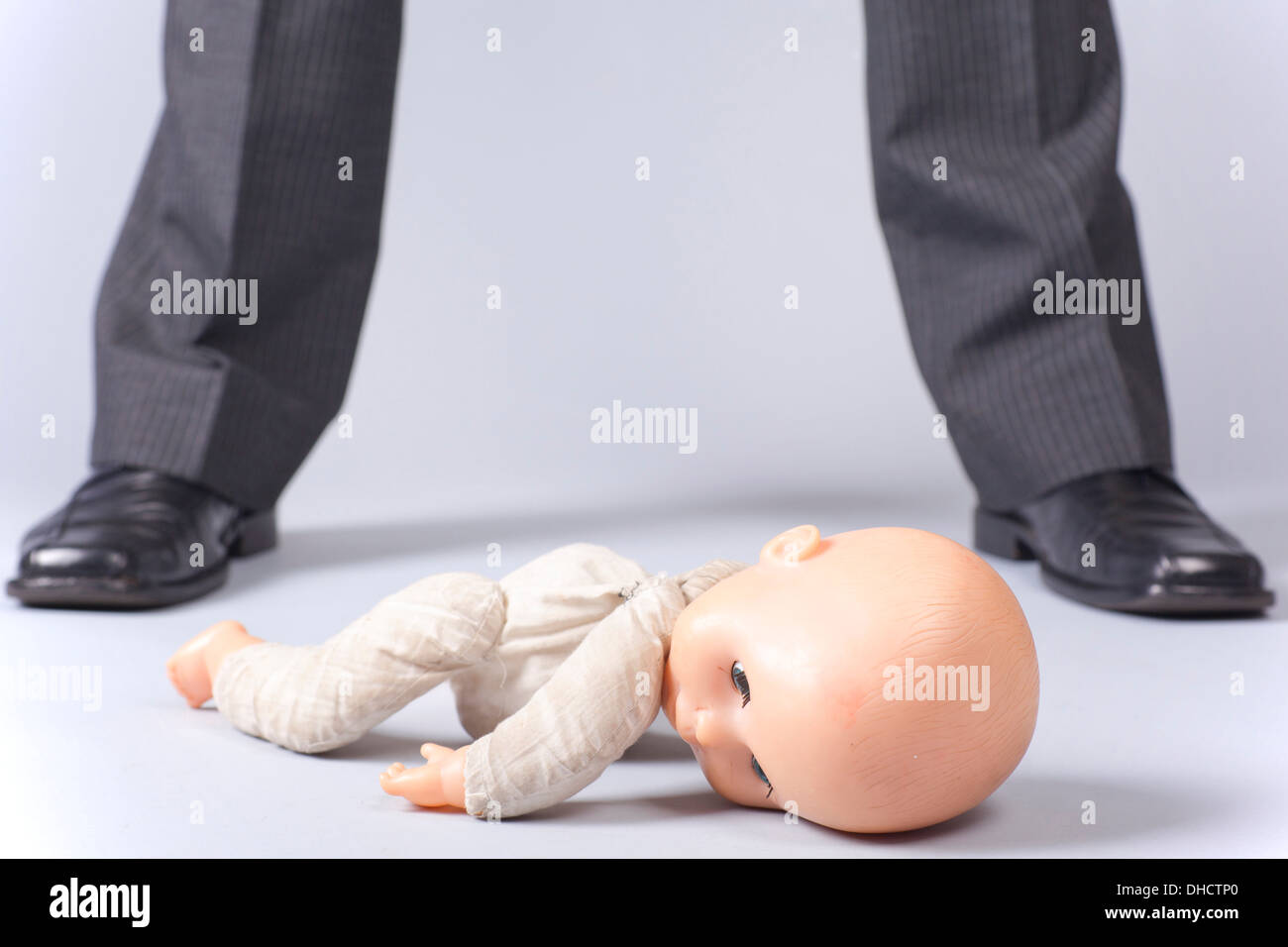 A puppet lying on the ground, in the background standing a man Stock ...