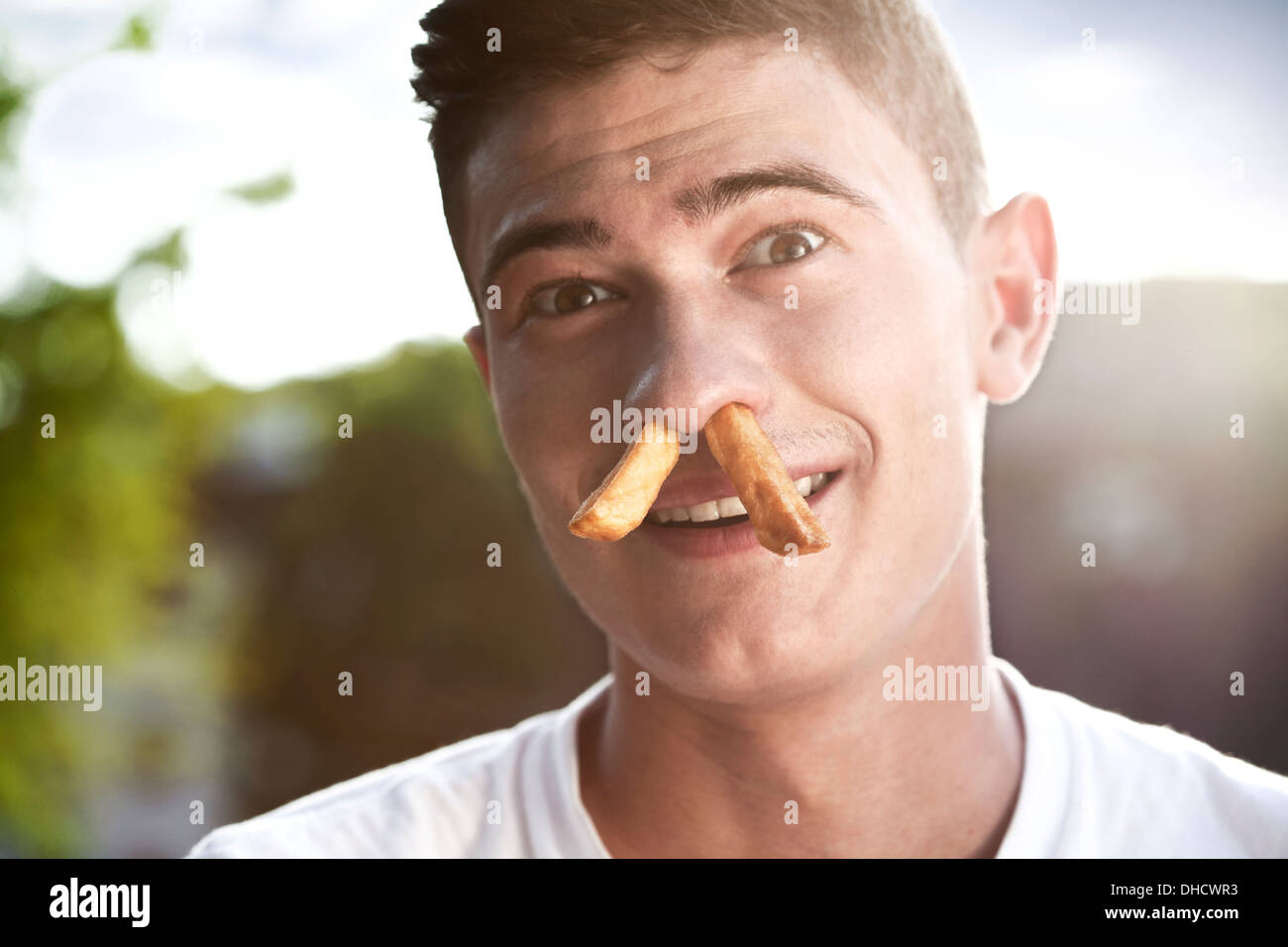 Young man with two french fries in his nose Stock Photo - Alamy