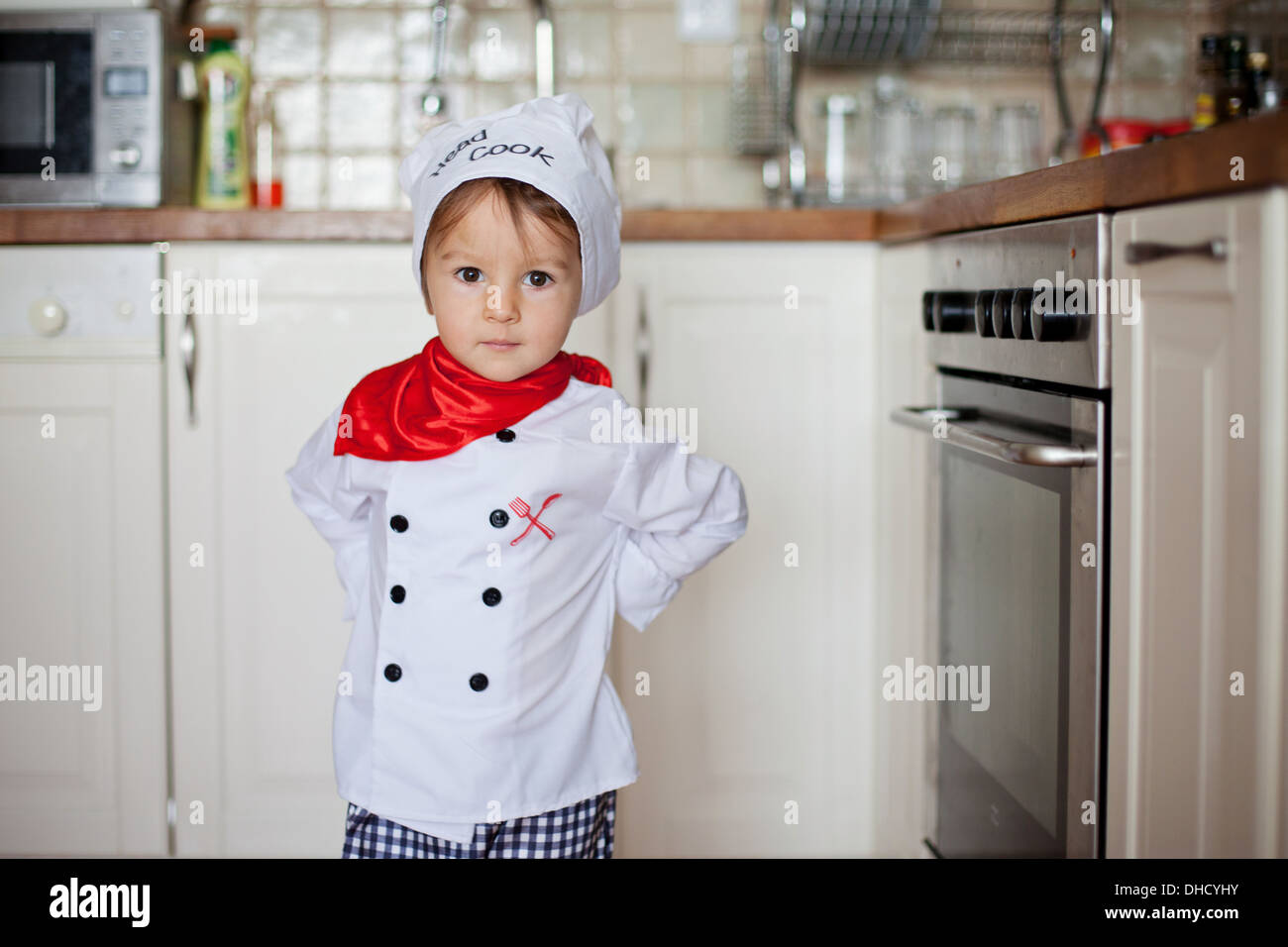 Boy, dressed like cook in a kitchen Stock Photo - Alamy