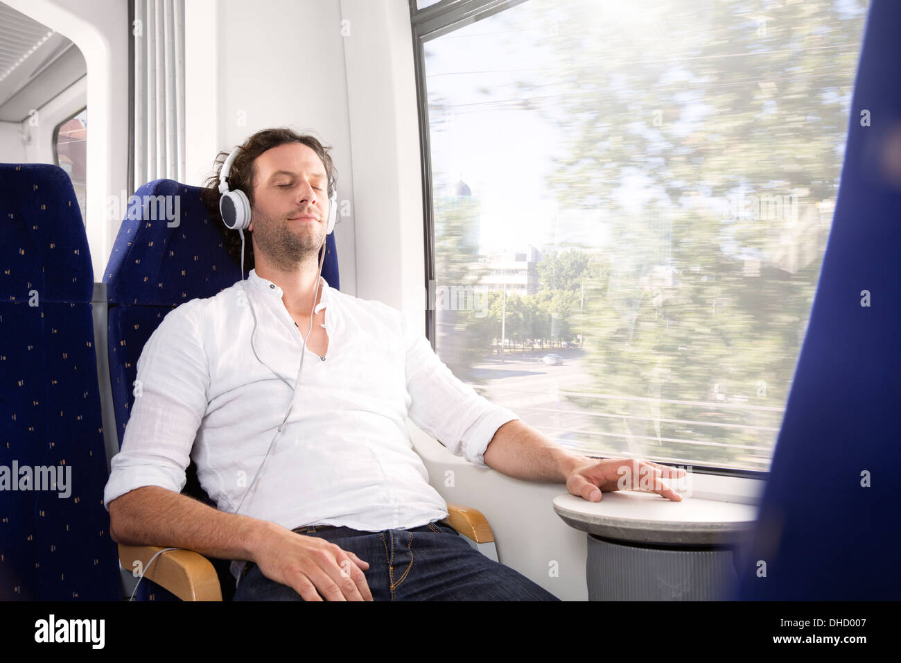 Man with headphones in a train Stock Photo - Alamy