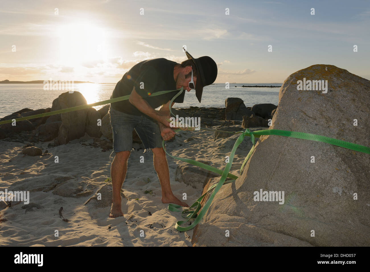France, Bretagne, Landeda, Man fixing slackline on beach Stock Photo ...