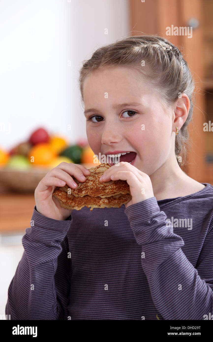 Little girl eating a crepe Stock Photo - Alamy
