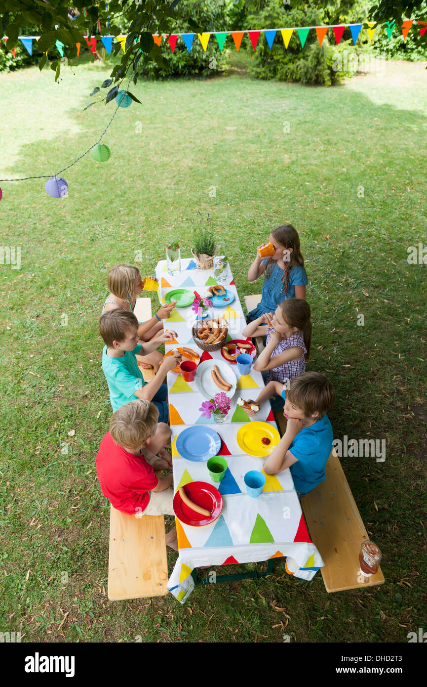 Children sitting at table on a birthday party Stock Photo - Alamy