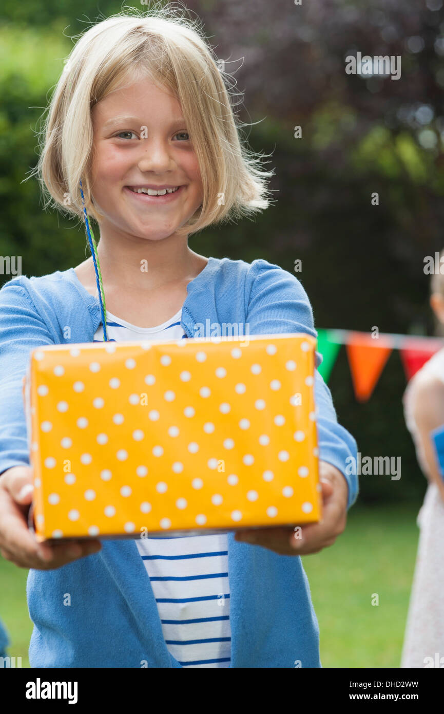 Girl handing over birthday present Stock Photo - Alamy