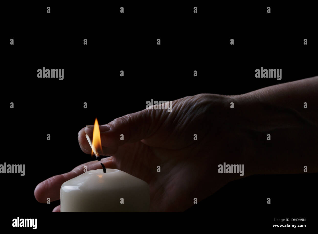 old woman hand set fire a candle, black background Stock Photo - Alamy