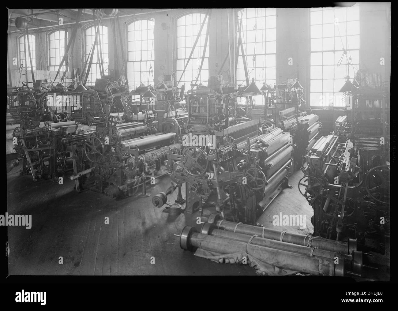The image shows idle looms in a textile factory in Paterson, New Jersey ...