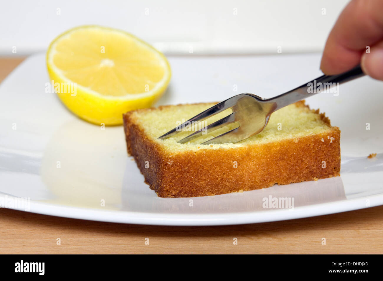 Slice of home made lemon cake on plate with lemon half Stock Photo - Alamy