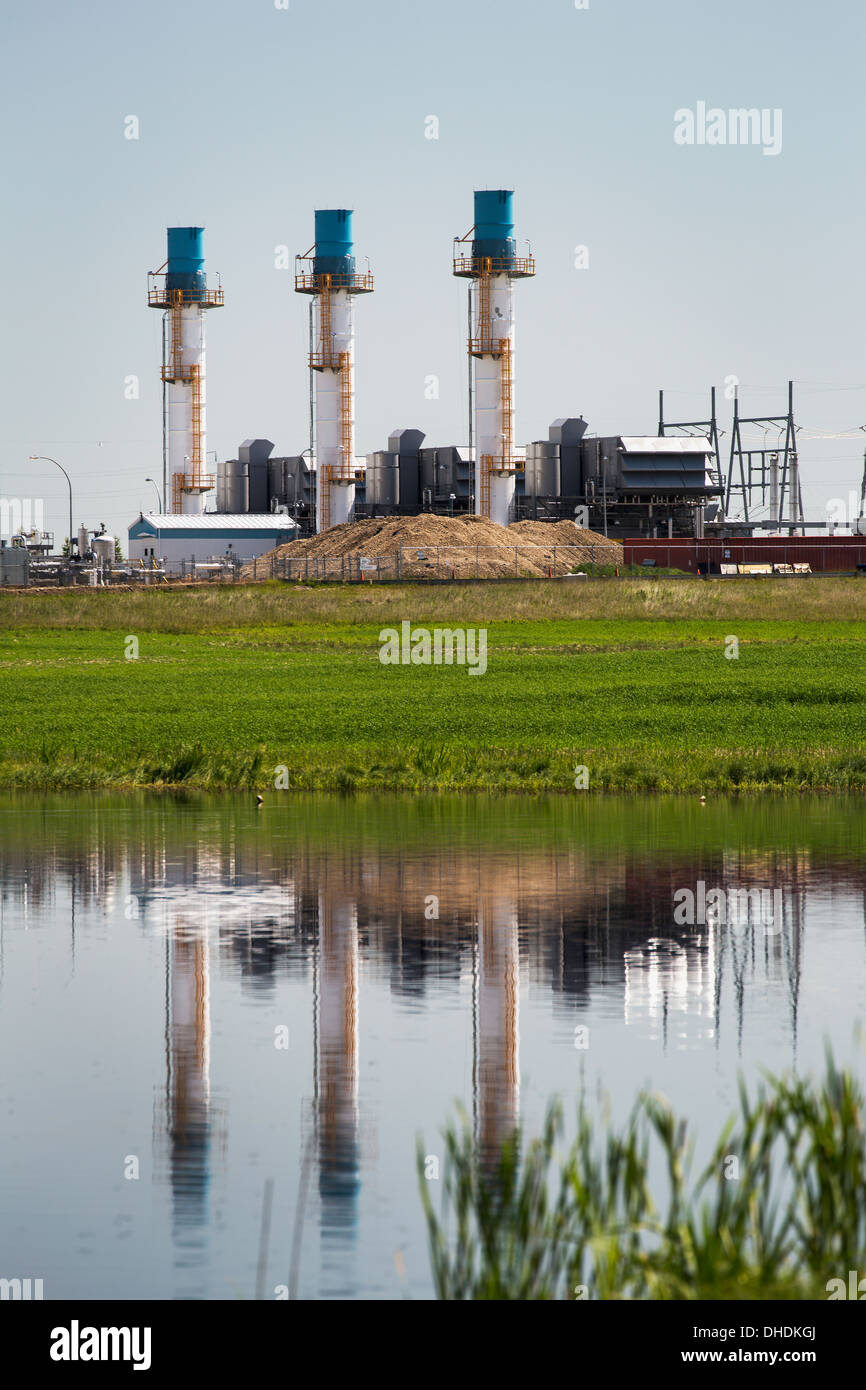 Gas Plant In A Green Field With Three Tall Stacks Reflecting In A Pond ...