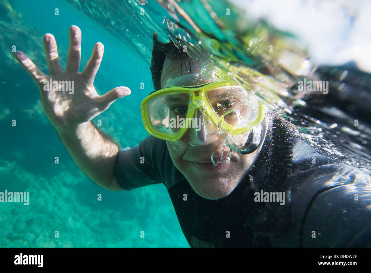 A Male Scuba Diver Waves Hello Underwater; Utila Island, Honduras Stock ...