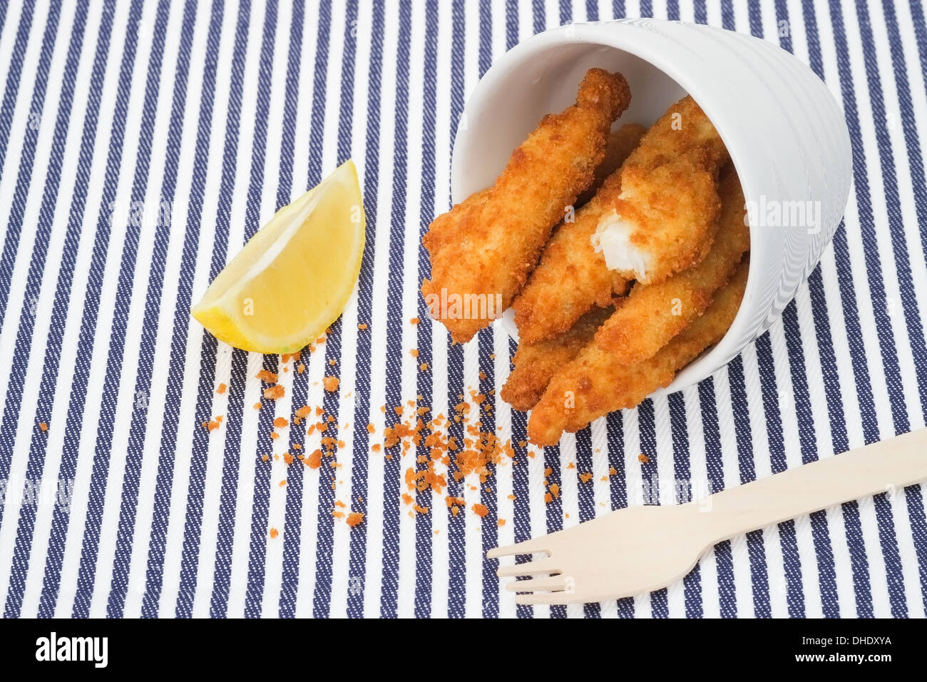 Deep fried fish finger sticks and a wedge of lemon Stock Photo - Alamy