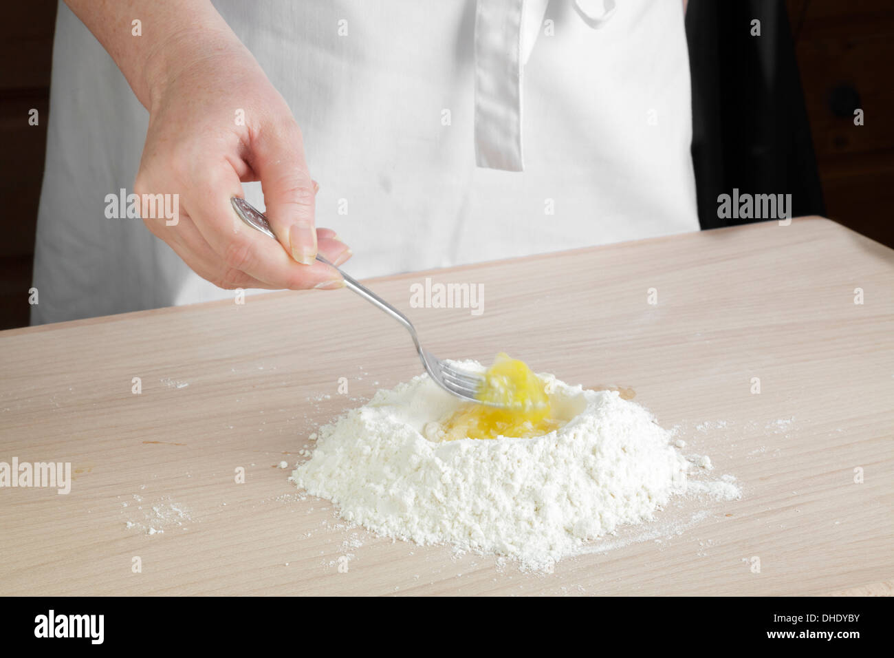 egg being mixed into flour on work surface Stock Photo - Alamy