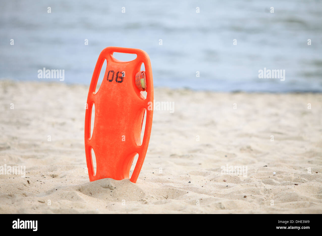 Beach life-saving. Lifeguard rescue equipment orange preserver tool, red plastic buoyancy aid in ...