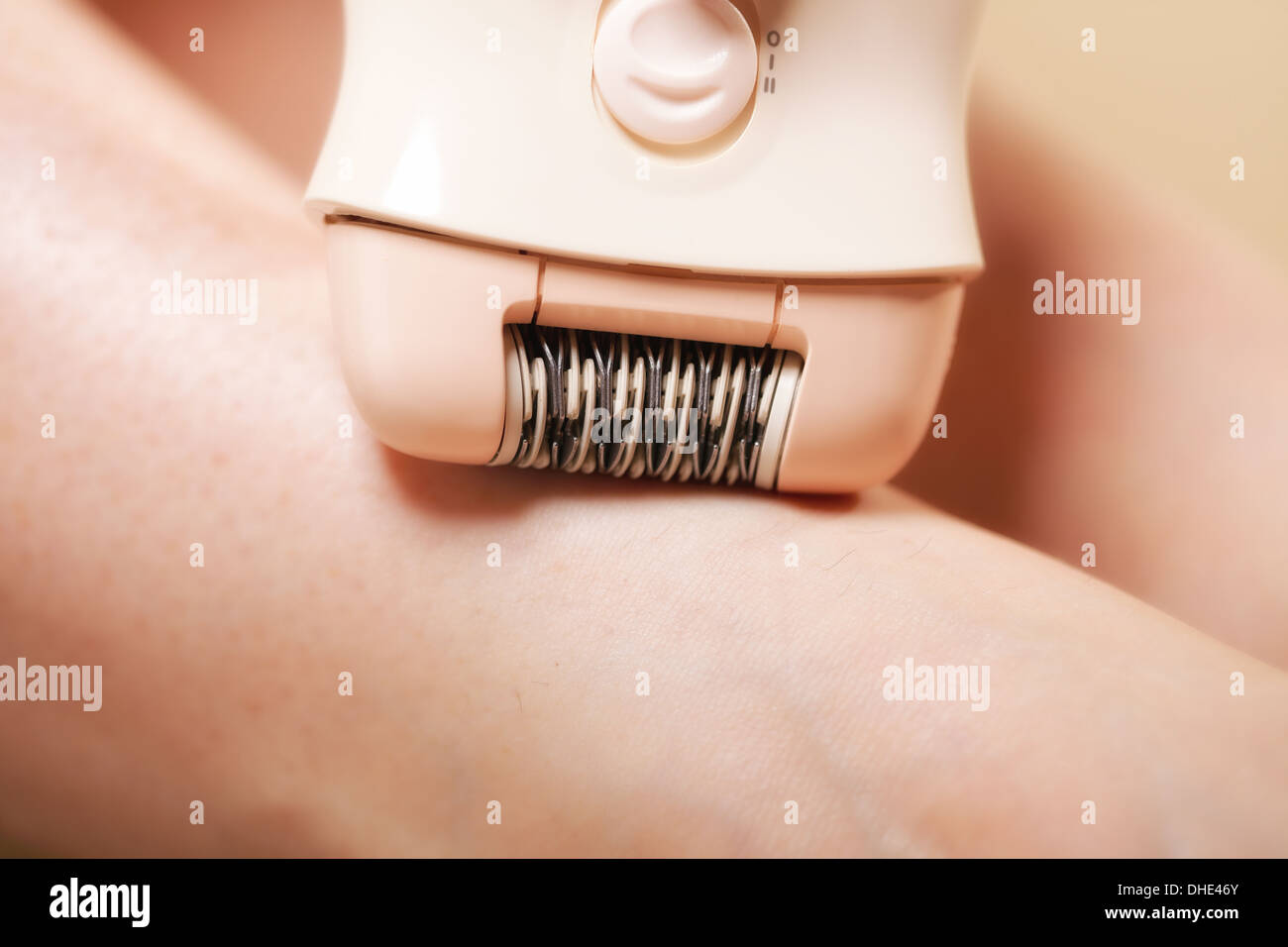 woman shaving her legs with electric shaver depilation on orange ...