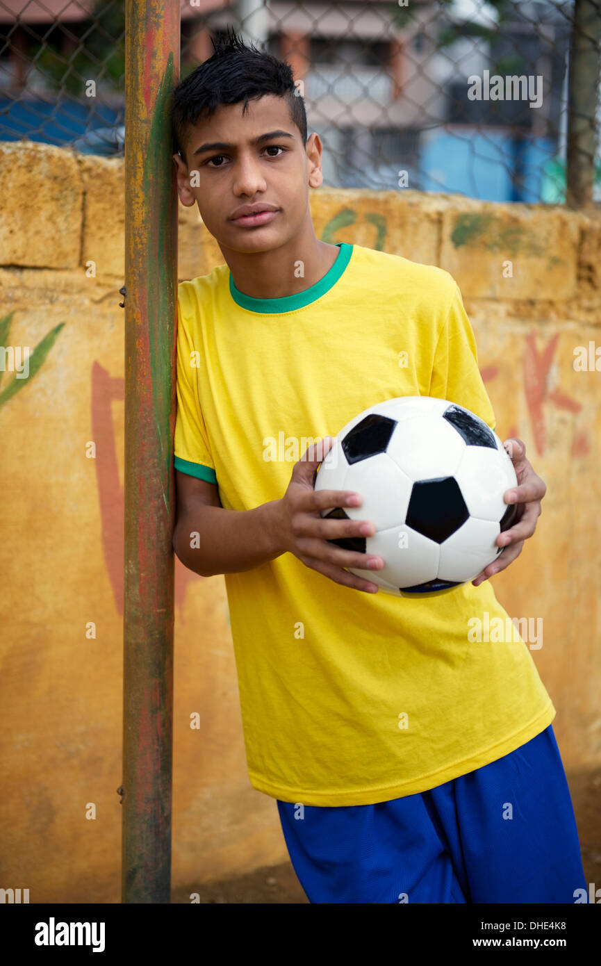 Portrait of young Brazilian soccer player holding football ball ...