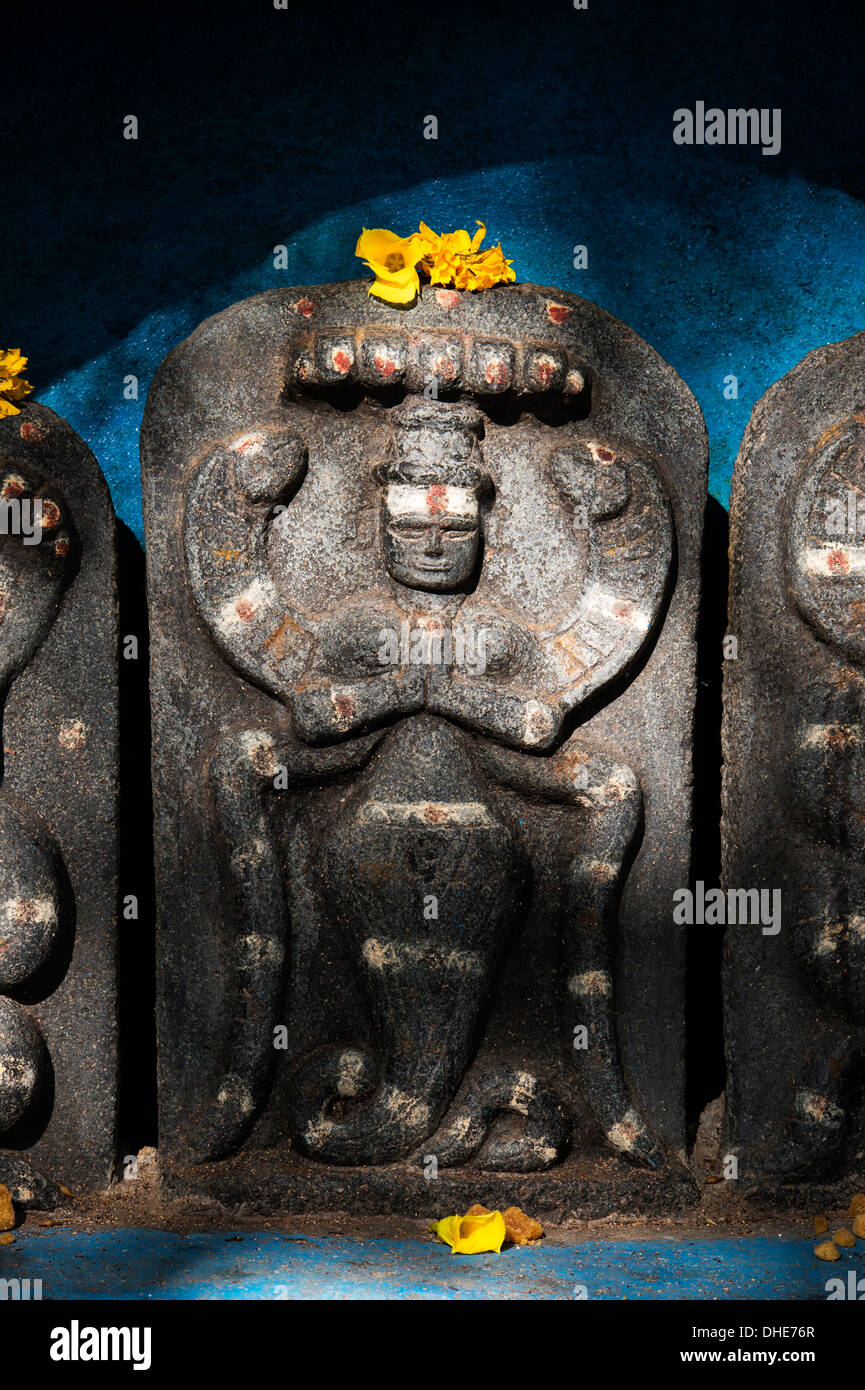 Hindu shrine stones at a temple depicting Indian vishnu deity in rural ...
