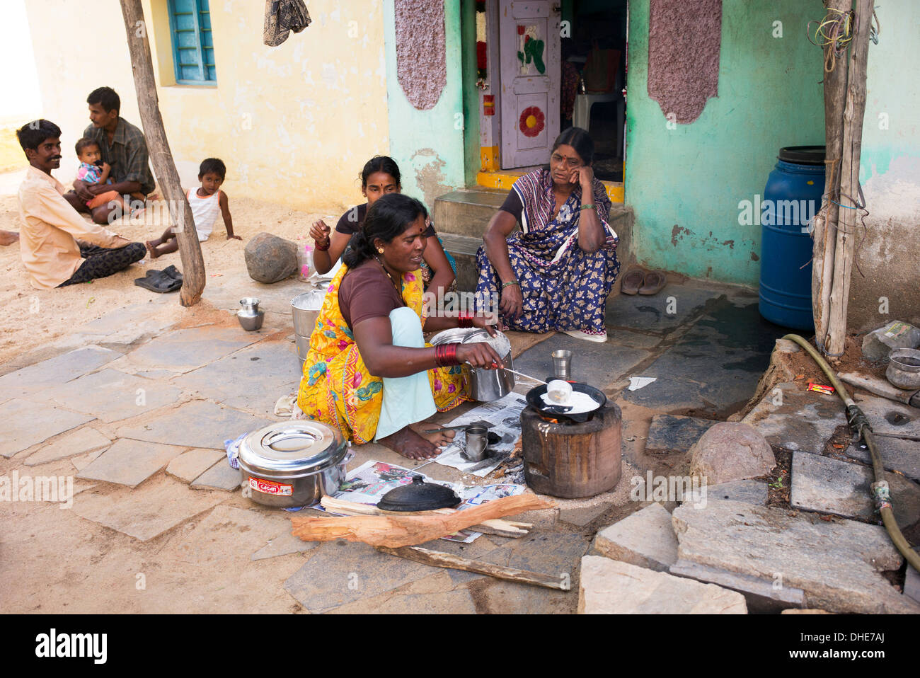 Indian woman cooking dosa for people outside a rural village house ...