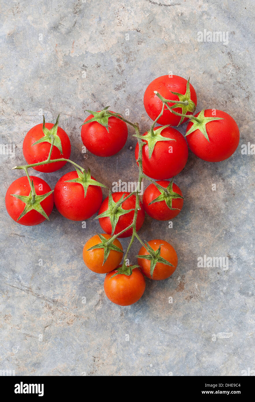 Bunches of cherry truss tomatoes on a stone surface Stock Photo - Alamy