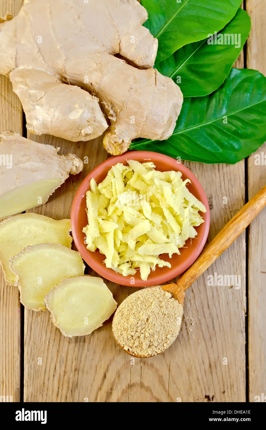 Brown dish with grated ginger, a wooden spoon with powder, ginger root ...