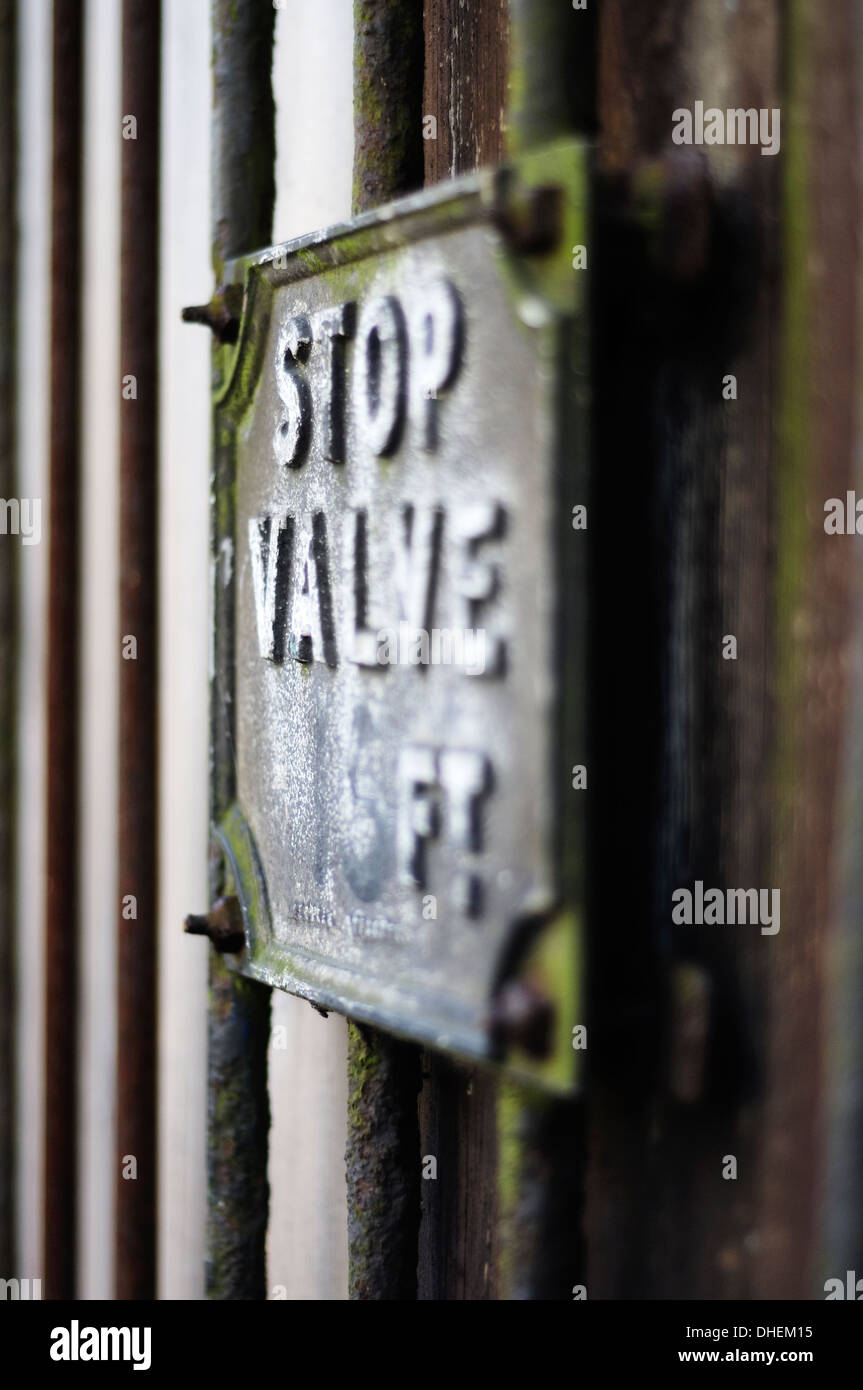 Cast metal Stop Valve sign fixed to an iron railing fence Stock Photo ...