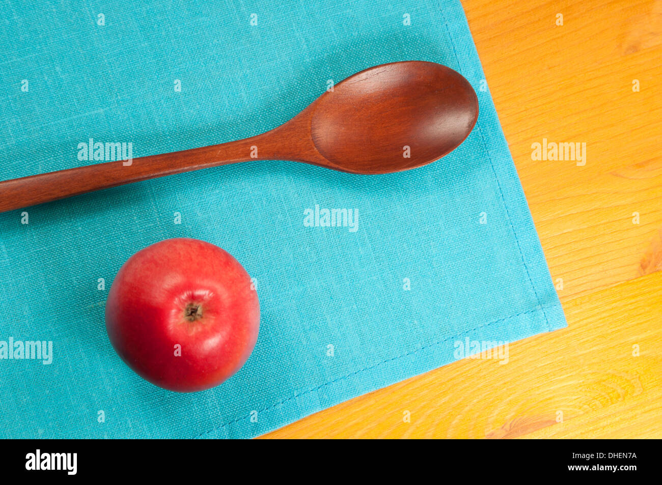 Apple and wooden spoon on a wooden table with blue napkin Stock Photo ...