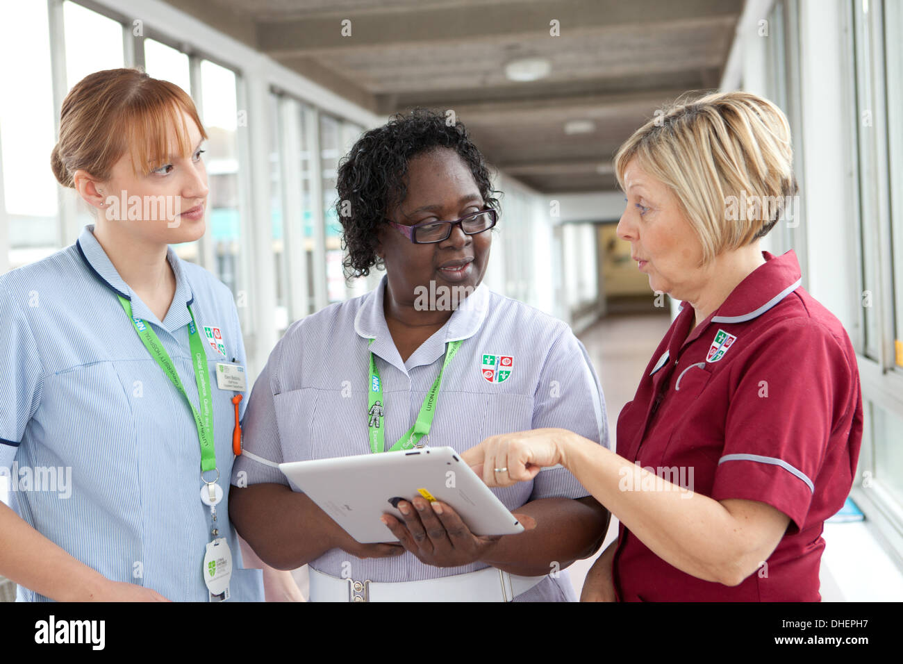 Three nurses use an iPad to look at a patients notes UK Stock Photo - Alamy