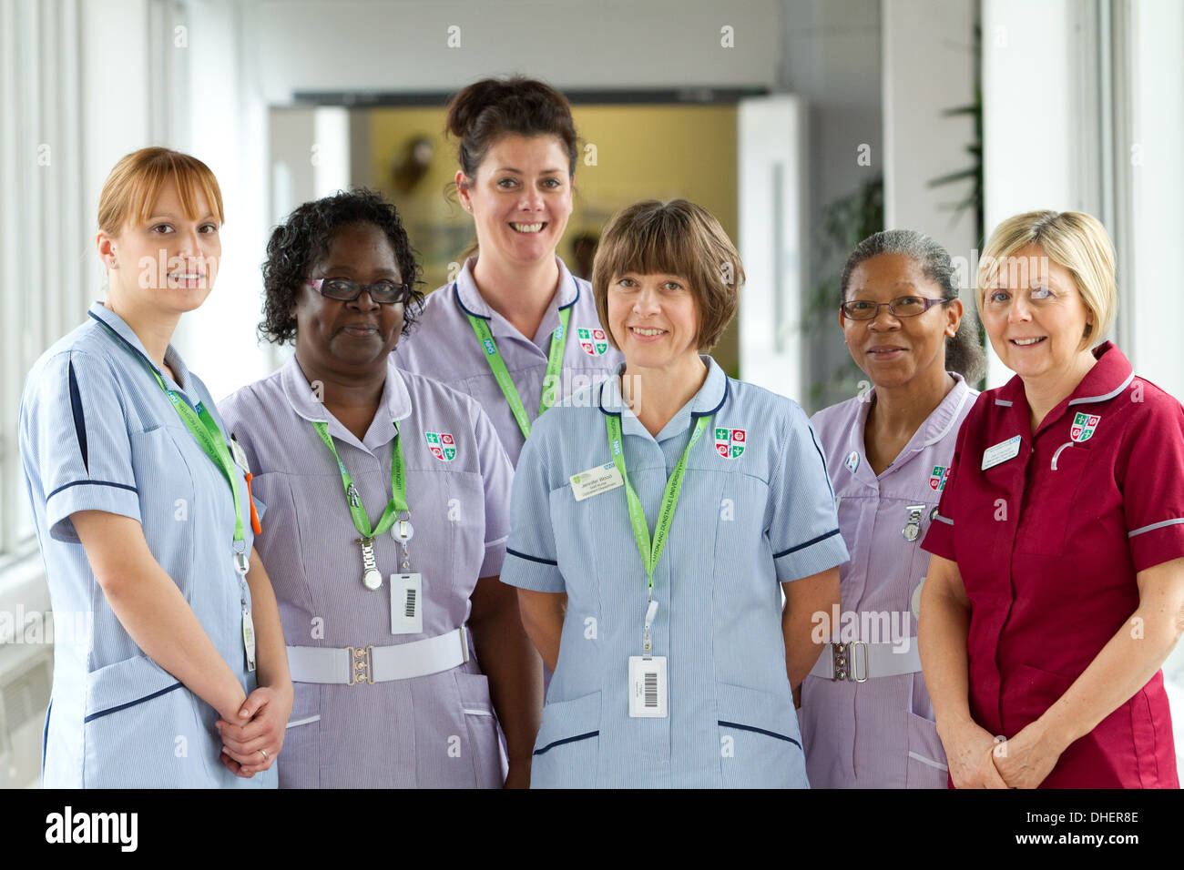 A group of 5 nurses smile toward the camera in a hospital corridor UK ...