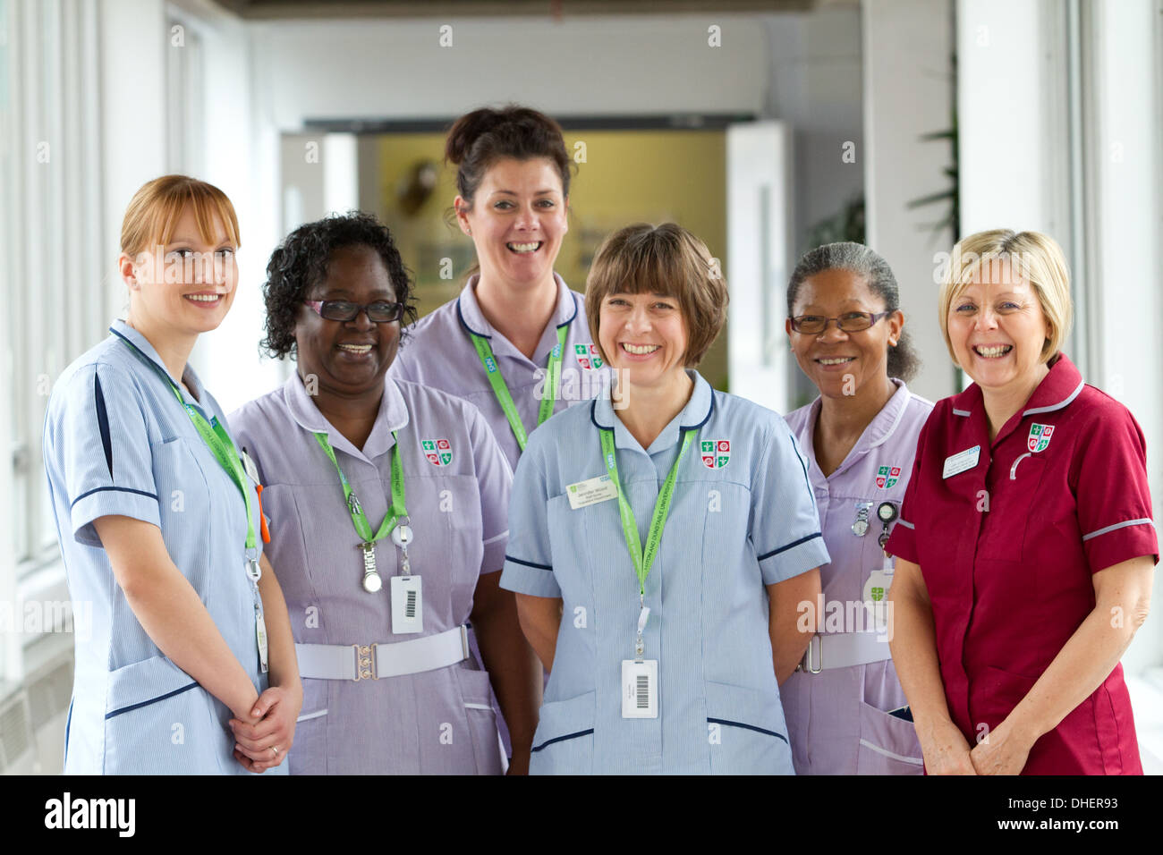 A group of 5 nurses smile toward the camera in a hospital corridor UK ...