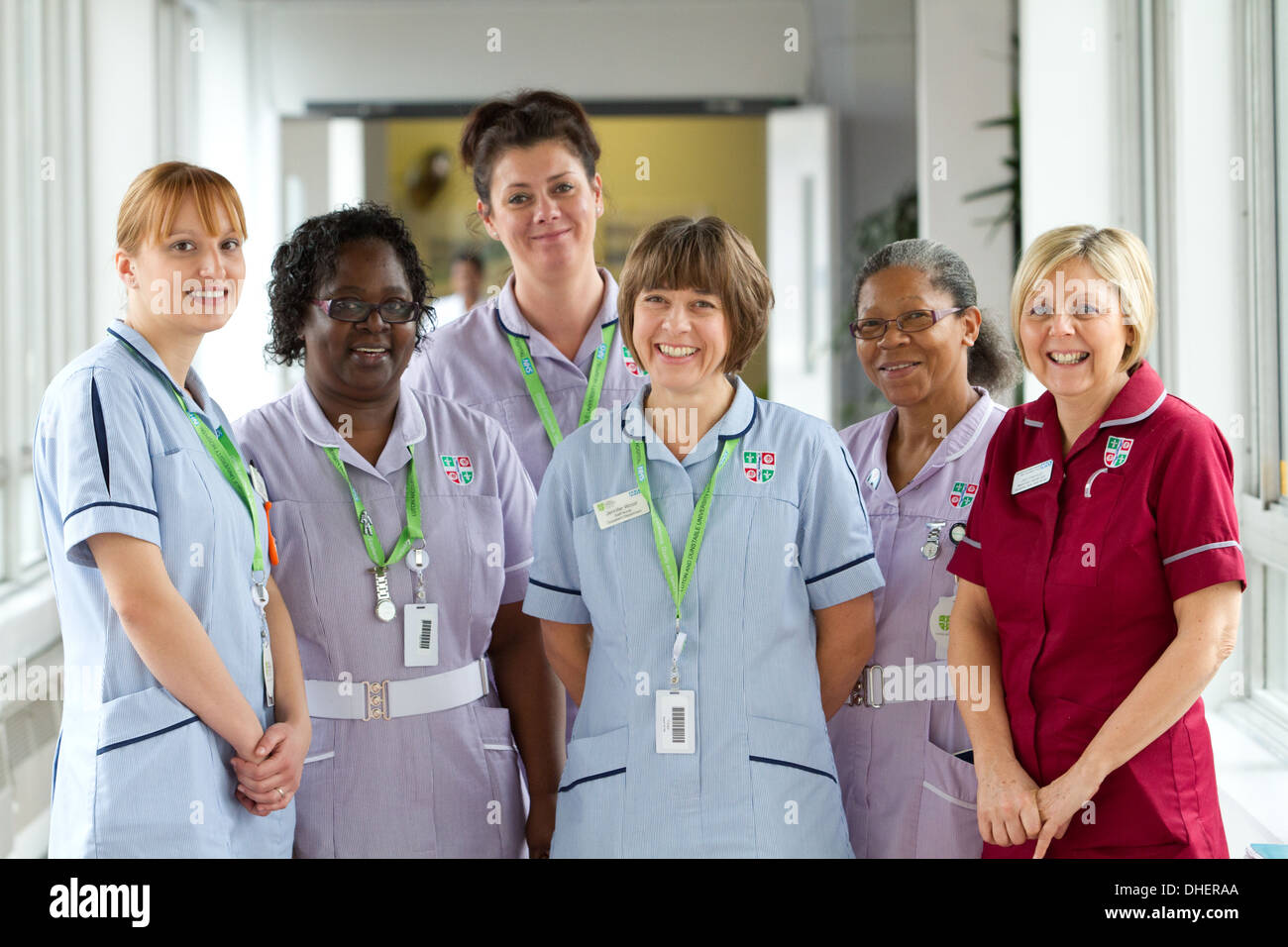 A group of 5 nurses smile toward the camera in a hospital corridor UK ...