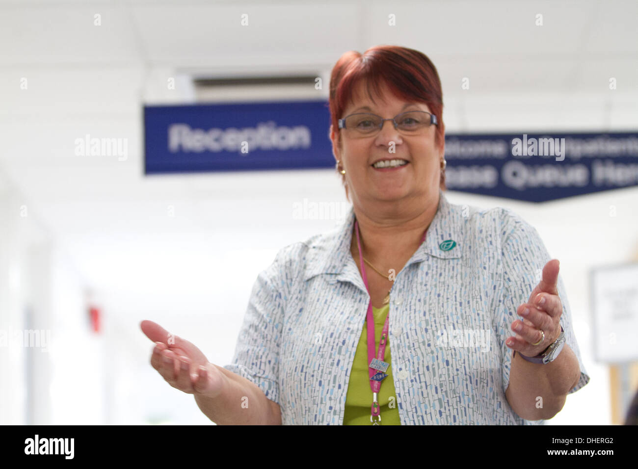 A welcoming hospital receptionist smiles to camera UK Stock Photo - Alamy