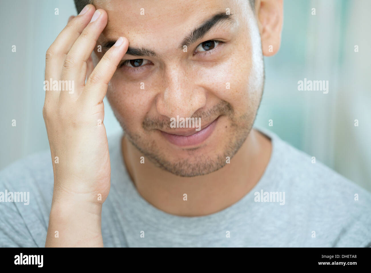 Mid adult man touching his face Stock Photo - Alamy