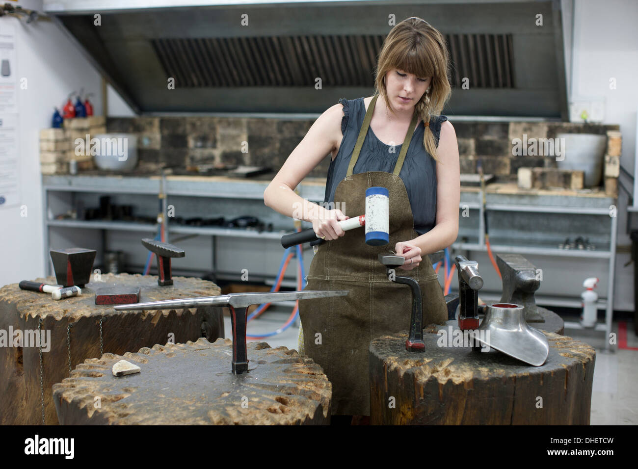 Woman metalworking using hammer Stock Photo - Alamy