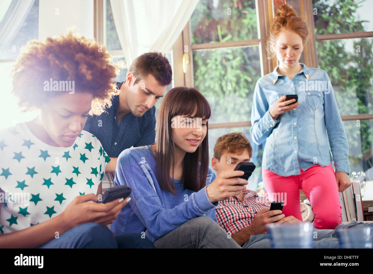Group of friends using smartphones Stock Photo - Alamy