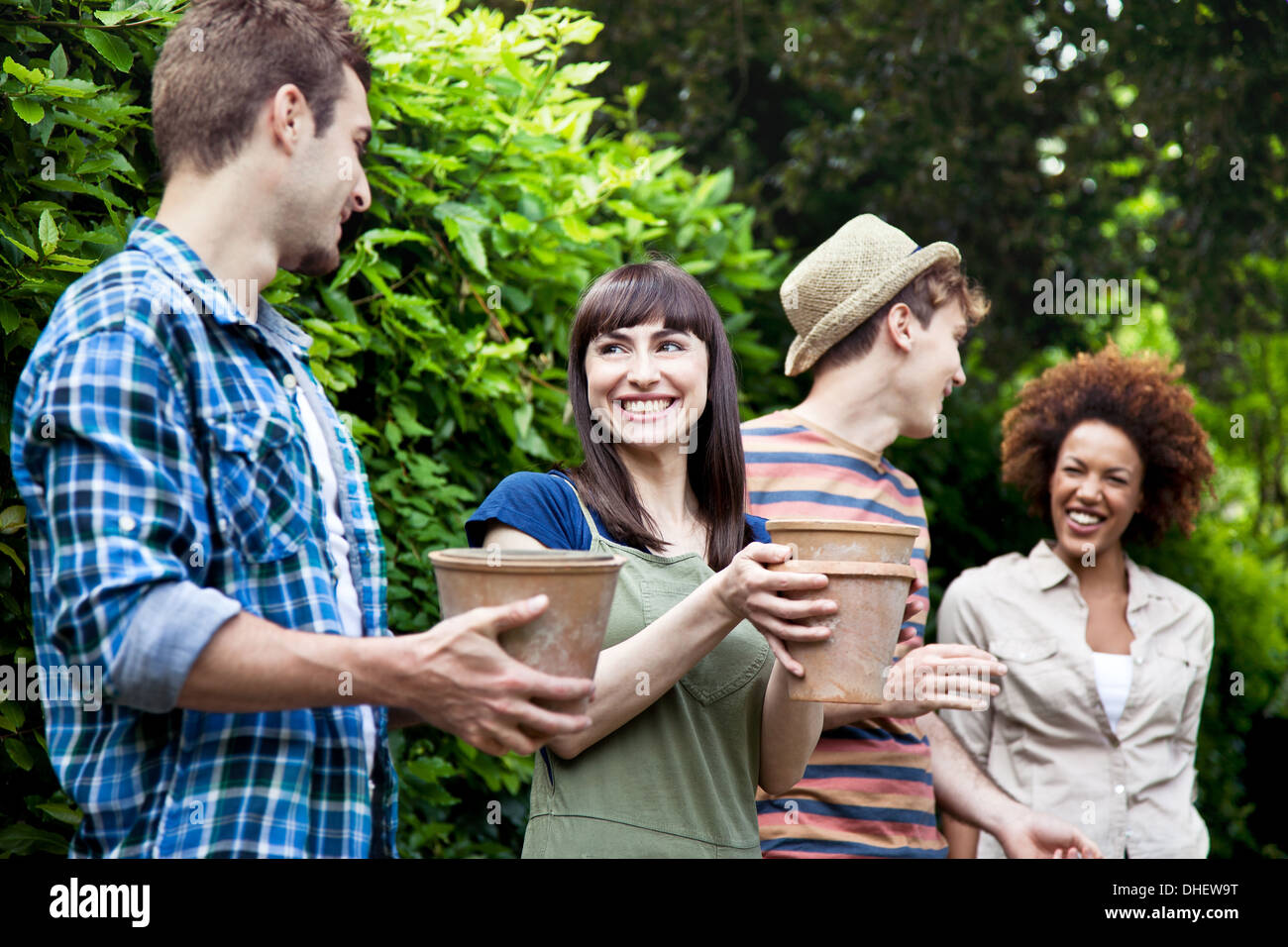 Four friends holding terracotta plant pots Stock Photo - Alamy