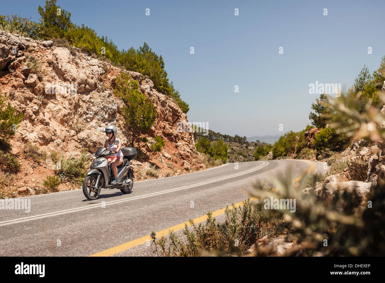 Woman riding moped along mountain road in Samos, Greece Stock Photo - Alamy