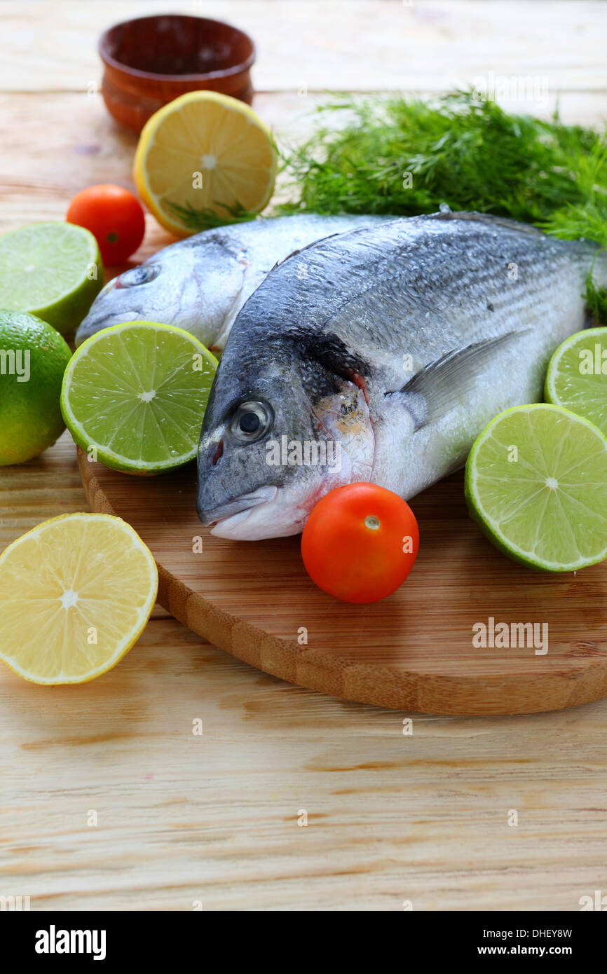 fresh fish on the board with lemons and limes, food Stock Photo - Alamy