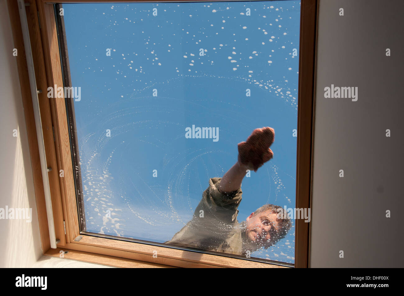 Man cleaning roof window Stock Photo - Alamy