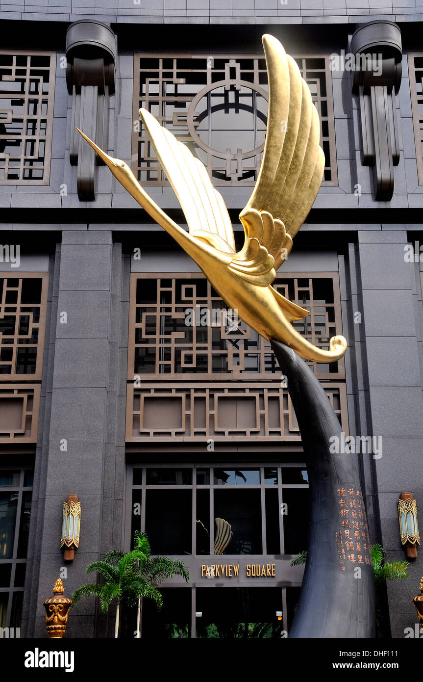 statue of a golden crane with its head lifted pointing towards the ...