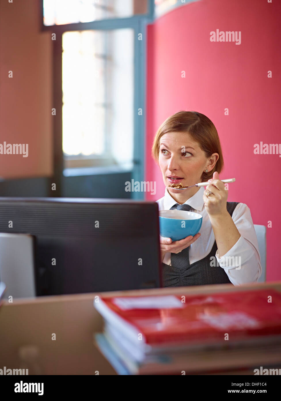 Woman eating at office desk hi-res stock photography and images - Alamy