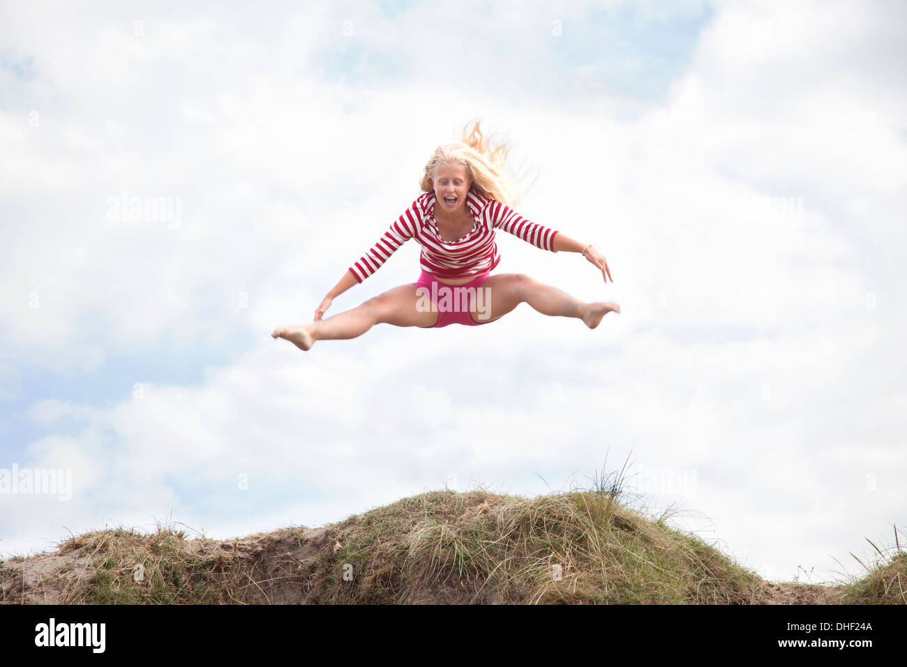 Teenage girl leaping mid air with legs out, Wales, UK Stock Photo - Alamy