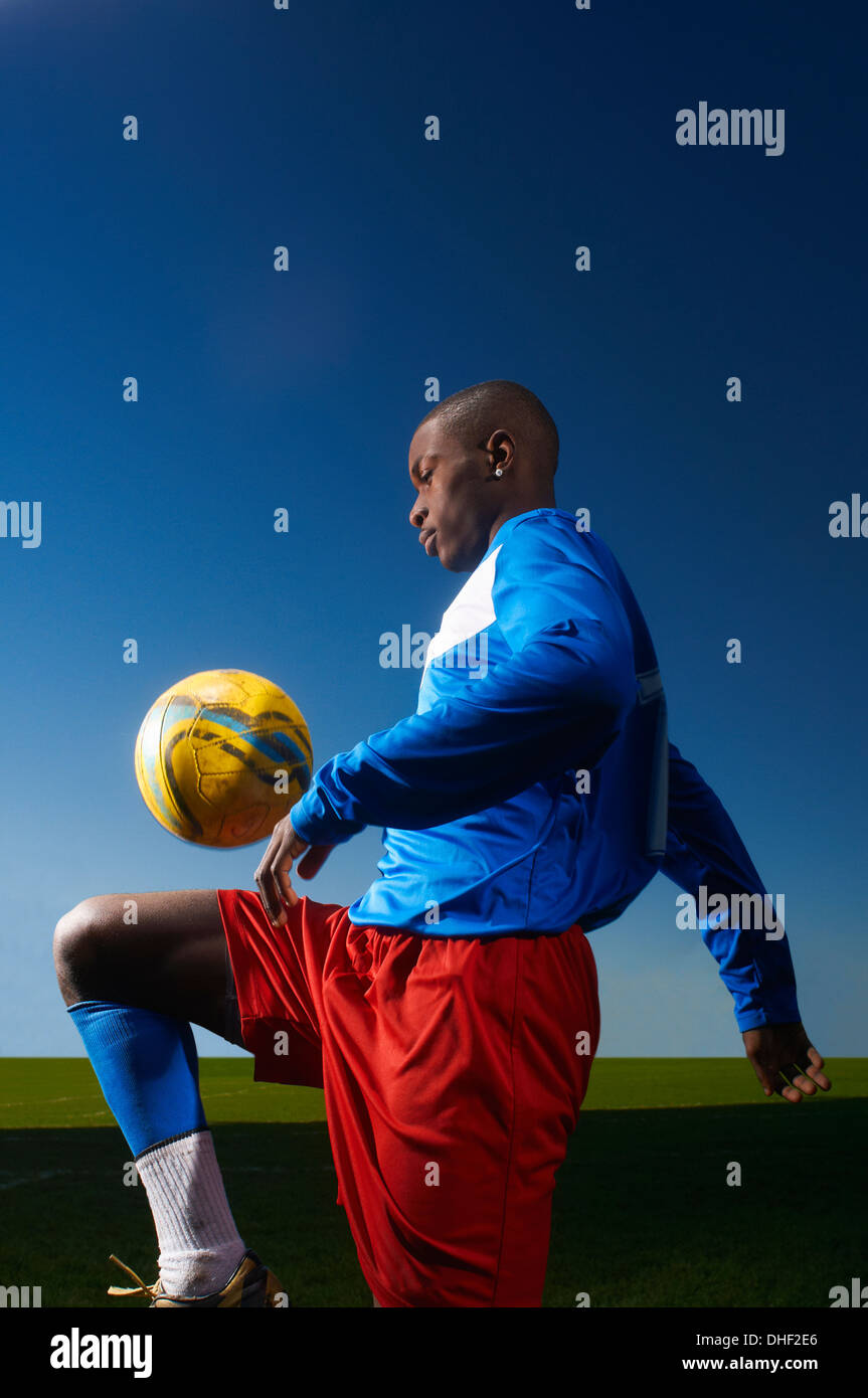 Young man playing keepy uppy with football Stock Photo - Alamy