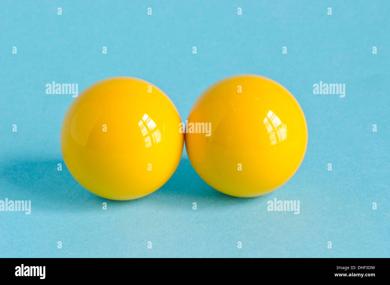 two yellow billiards ball on blue background Stock Photo - Alamy