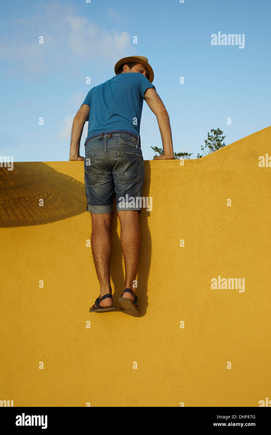 Man climbing over wall hi-res stock photography and images - Alamy