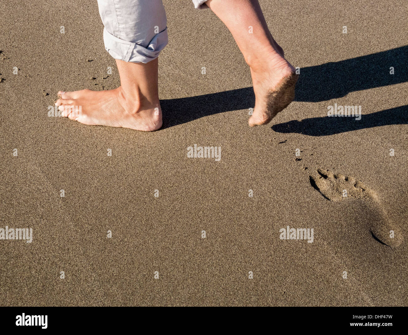 Walking in the sand of a beach Stock Photo - Alamy