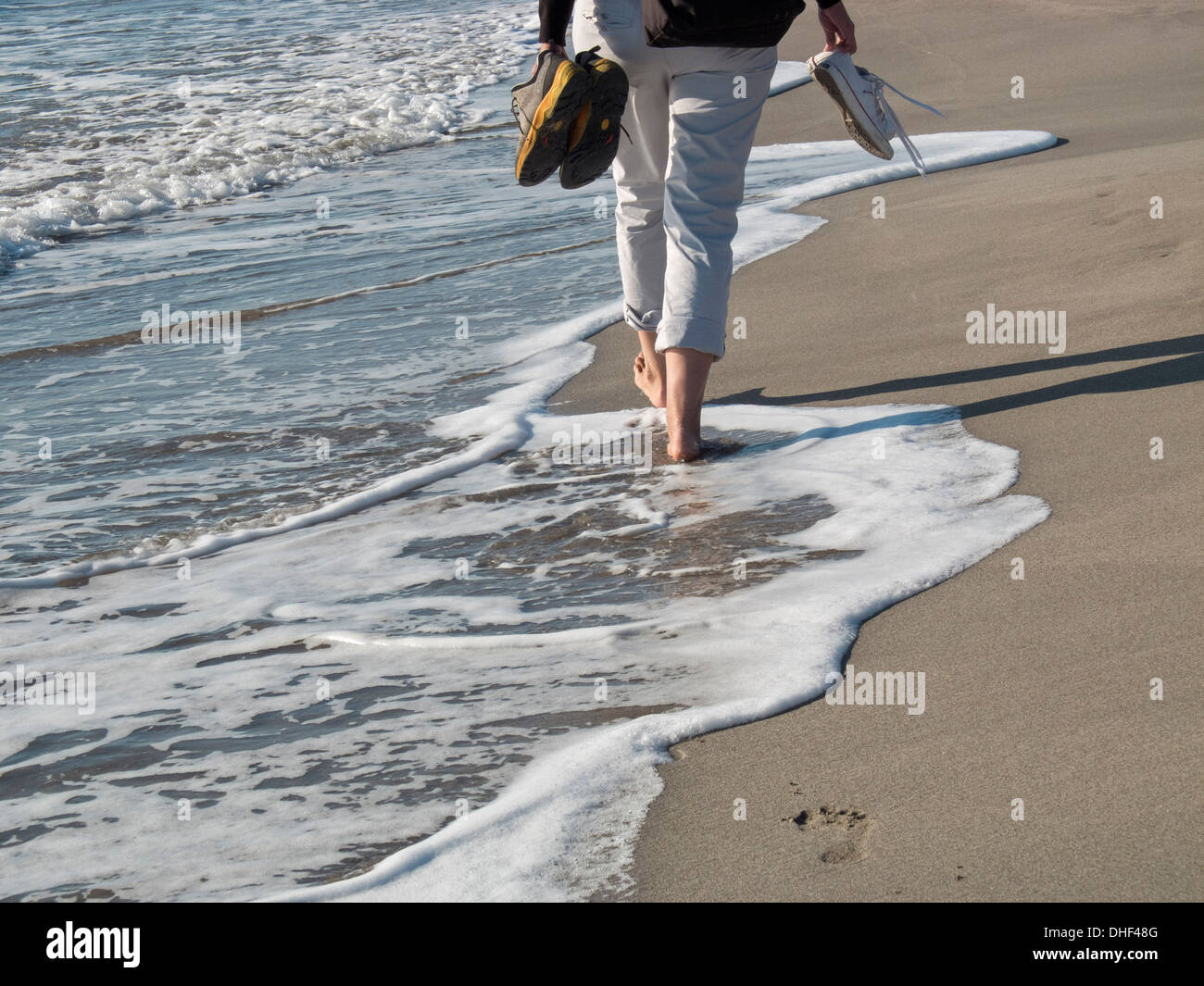 Walking in the sand of a beach Stock Photo - Alamy