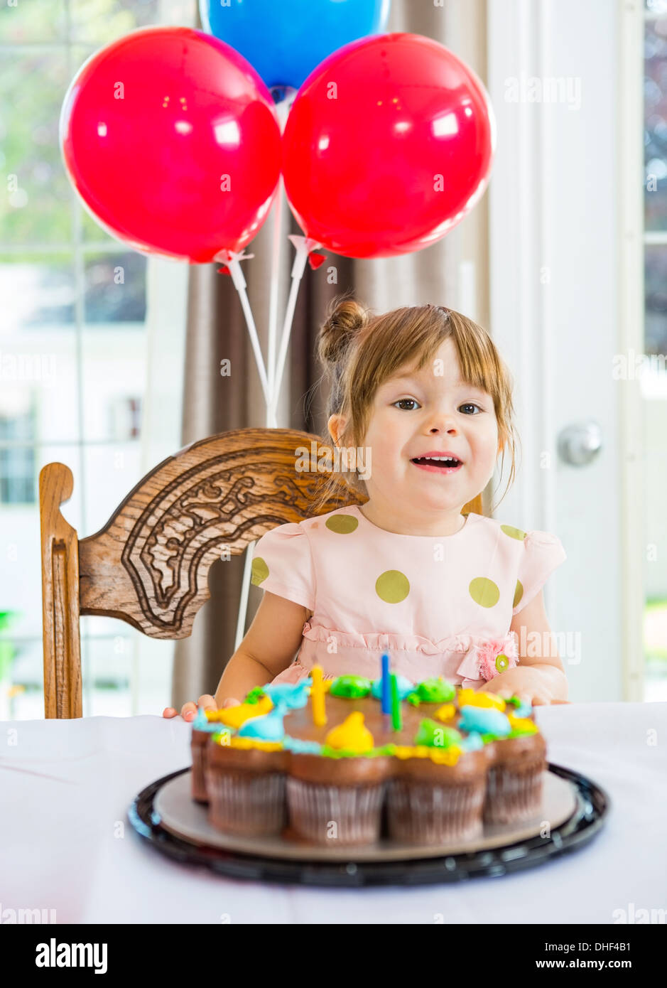 Girl Sitting In Front Of Cake At Home Stock Photo - Alamy