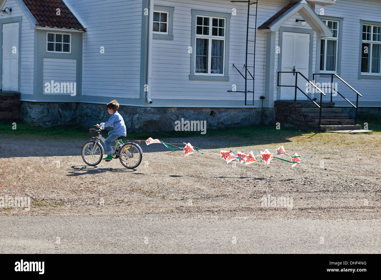 Boy riding bicycle pulling bunting Stock Photo - Alamy