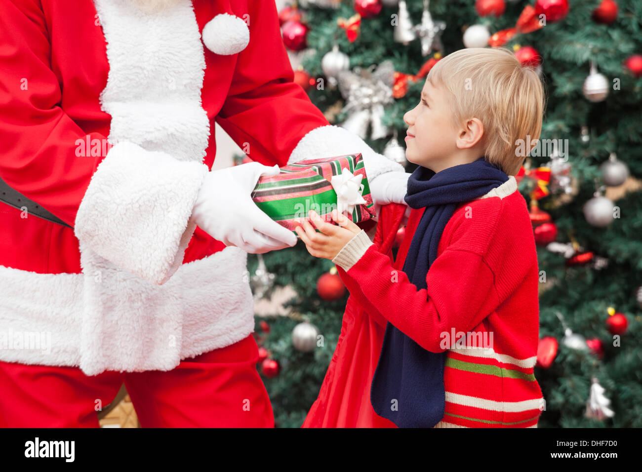 Santa Claus Giving Gift To Boy Stock Photo - Alamy