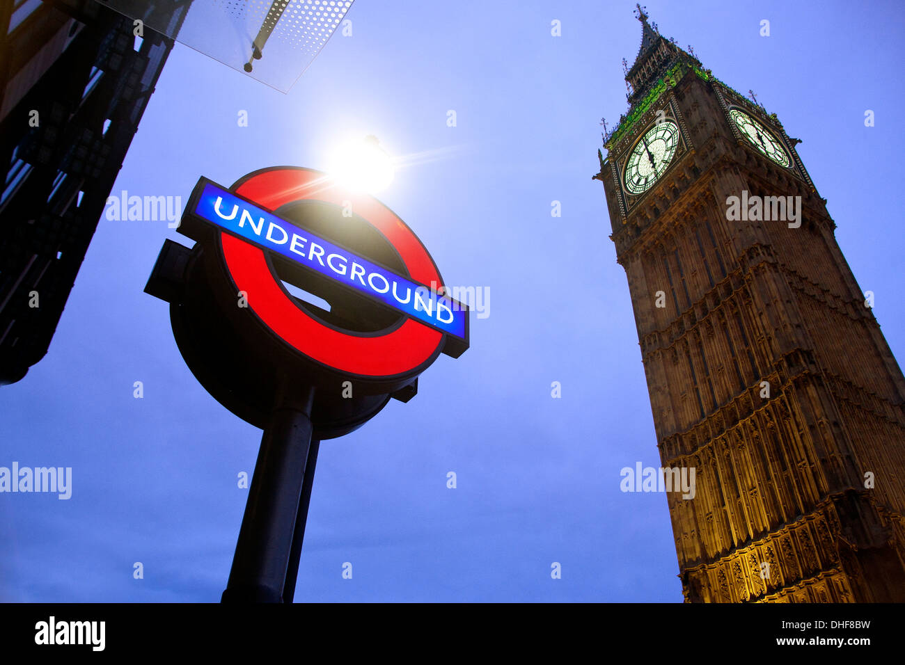 London underground sign post catching the sun with Big Ben in ...