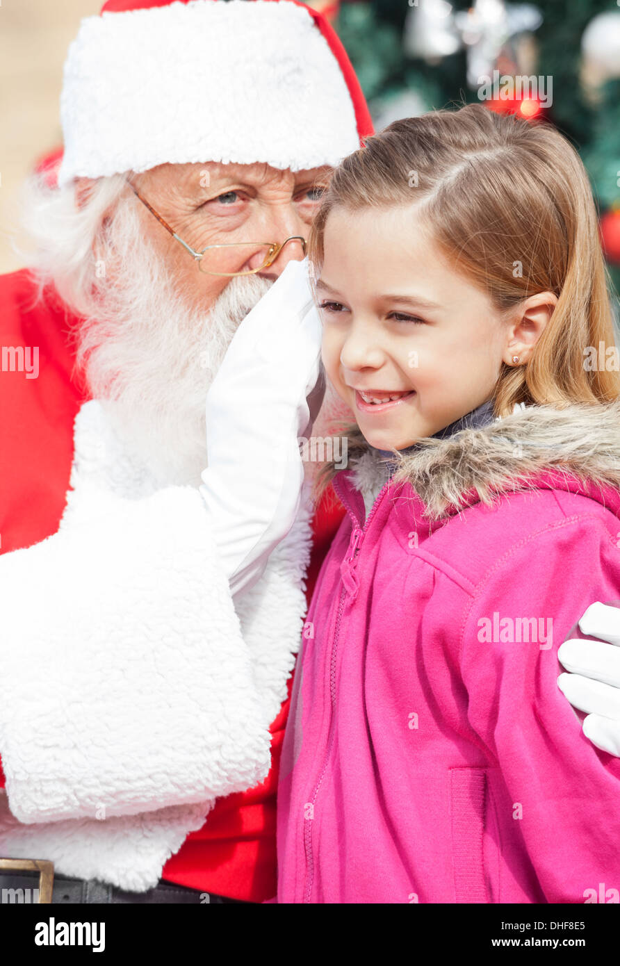 Santa Claus Whispering In Girl's Ear Stock Photo - Alamy