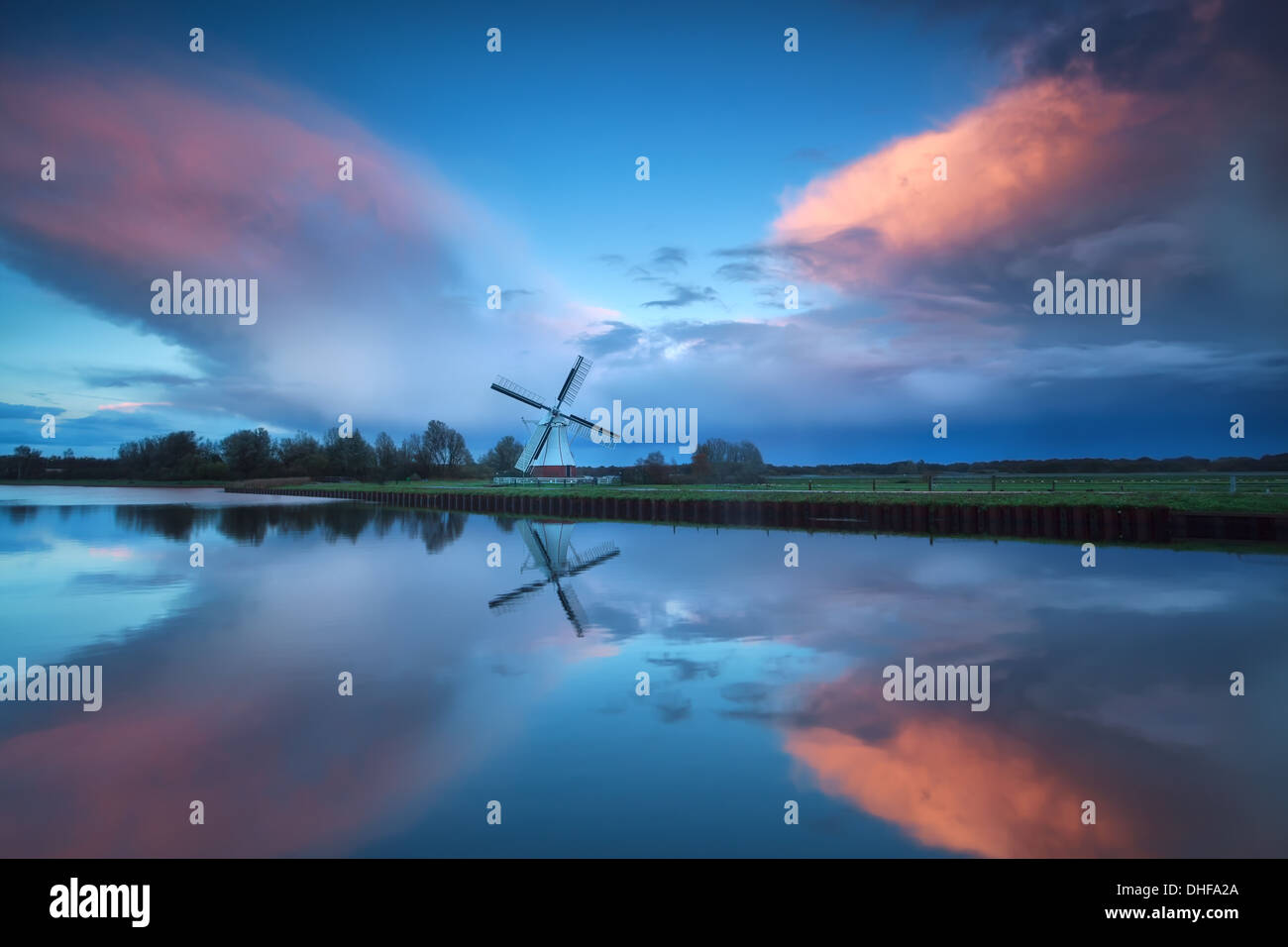 dramatic stormy sunset over Dutch windmill and river, Groningen ...